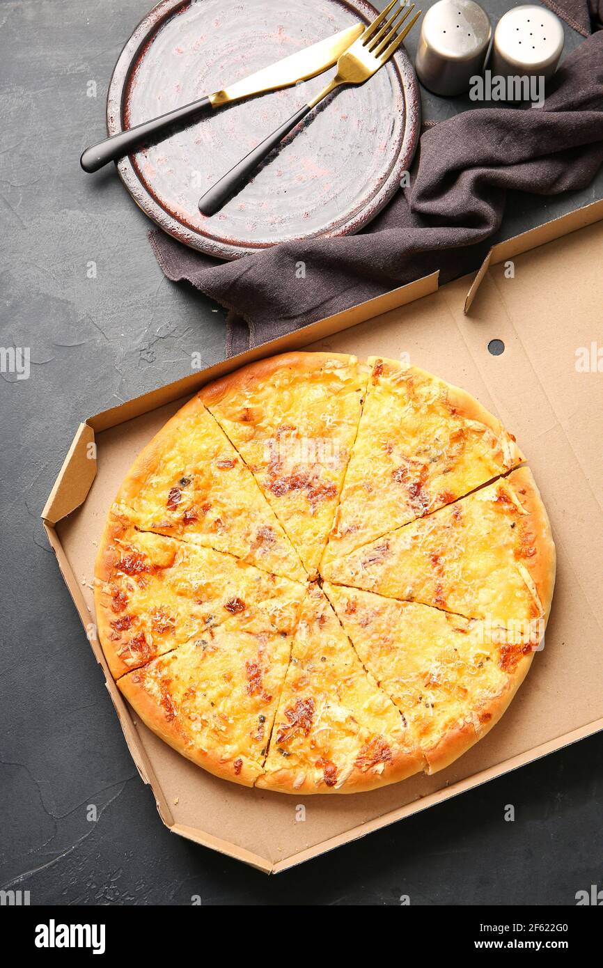 Cardboard box with tasty pizza on dark background Stock Photo - Alamy