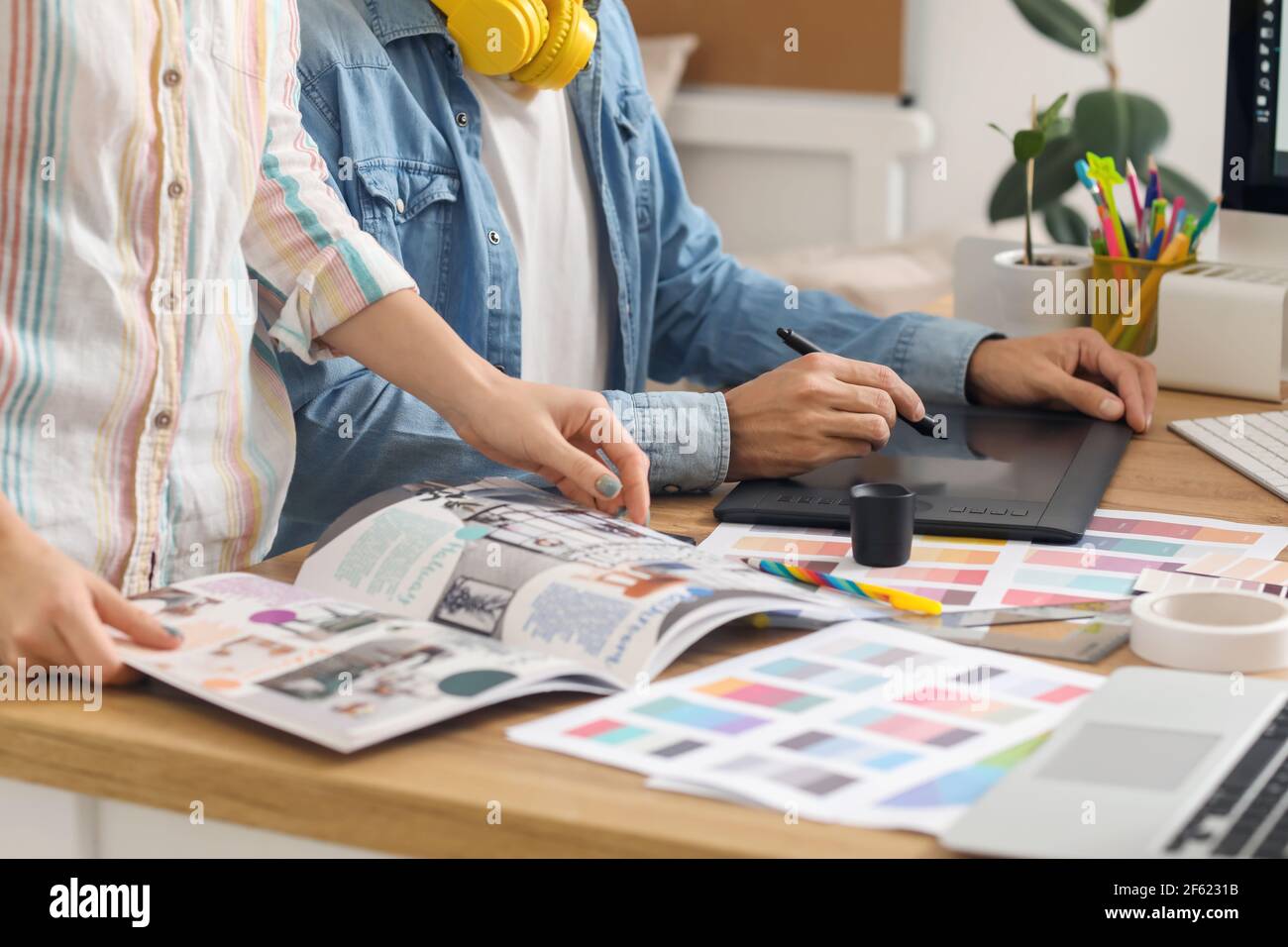 Graphic designer with colleague working in office Stock Photo - Alamy