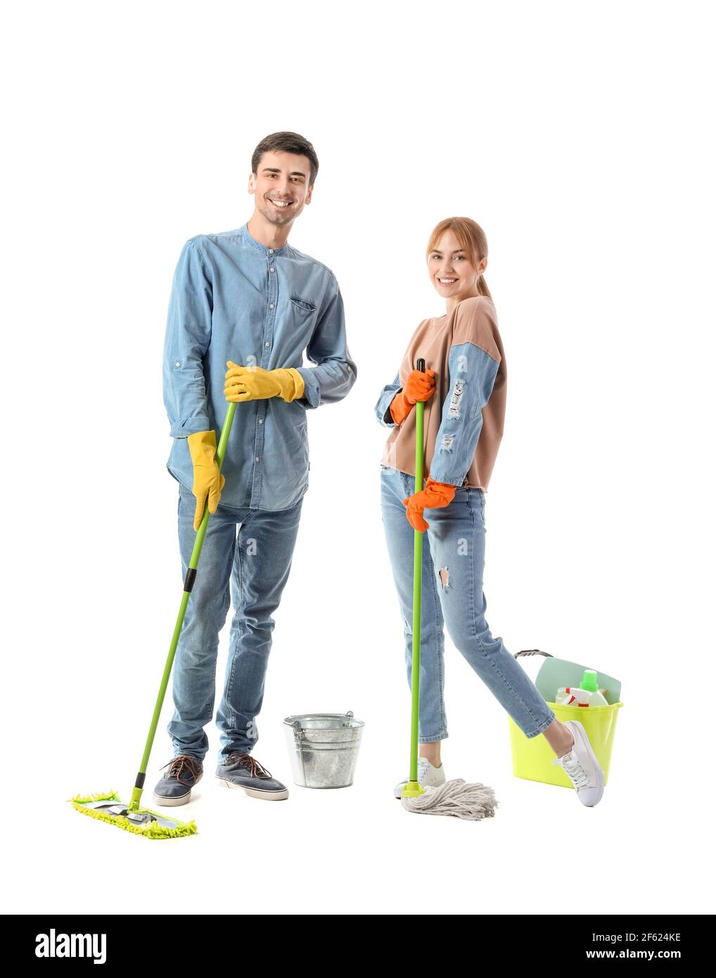 Young couple with cleaning supplies on white background Stock Photo - Alamy