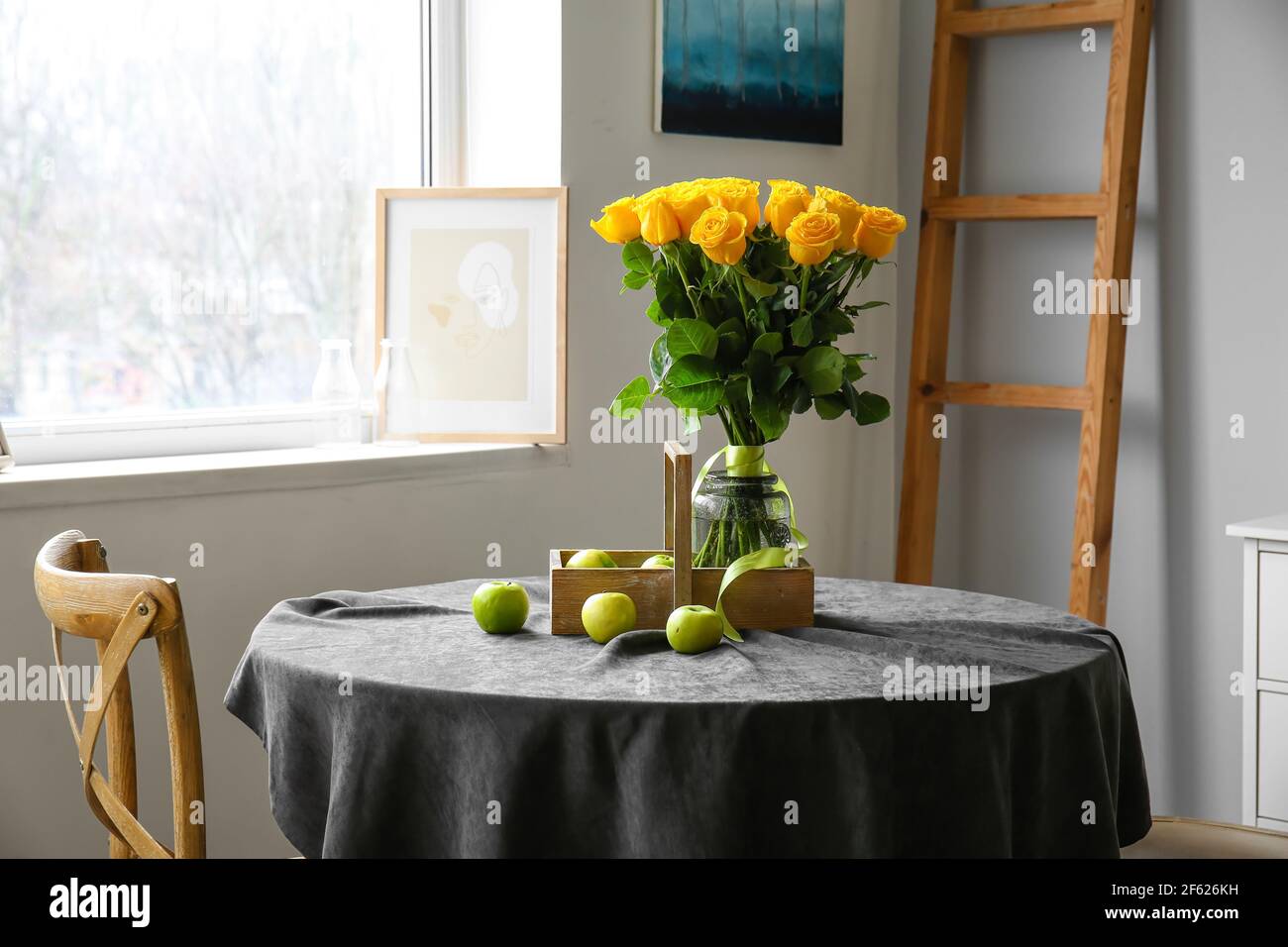 Vase with beautiful yellow roses on table in interior of room Stock ...