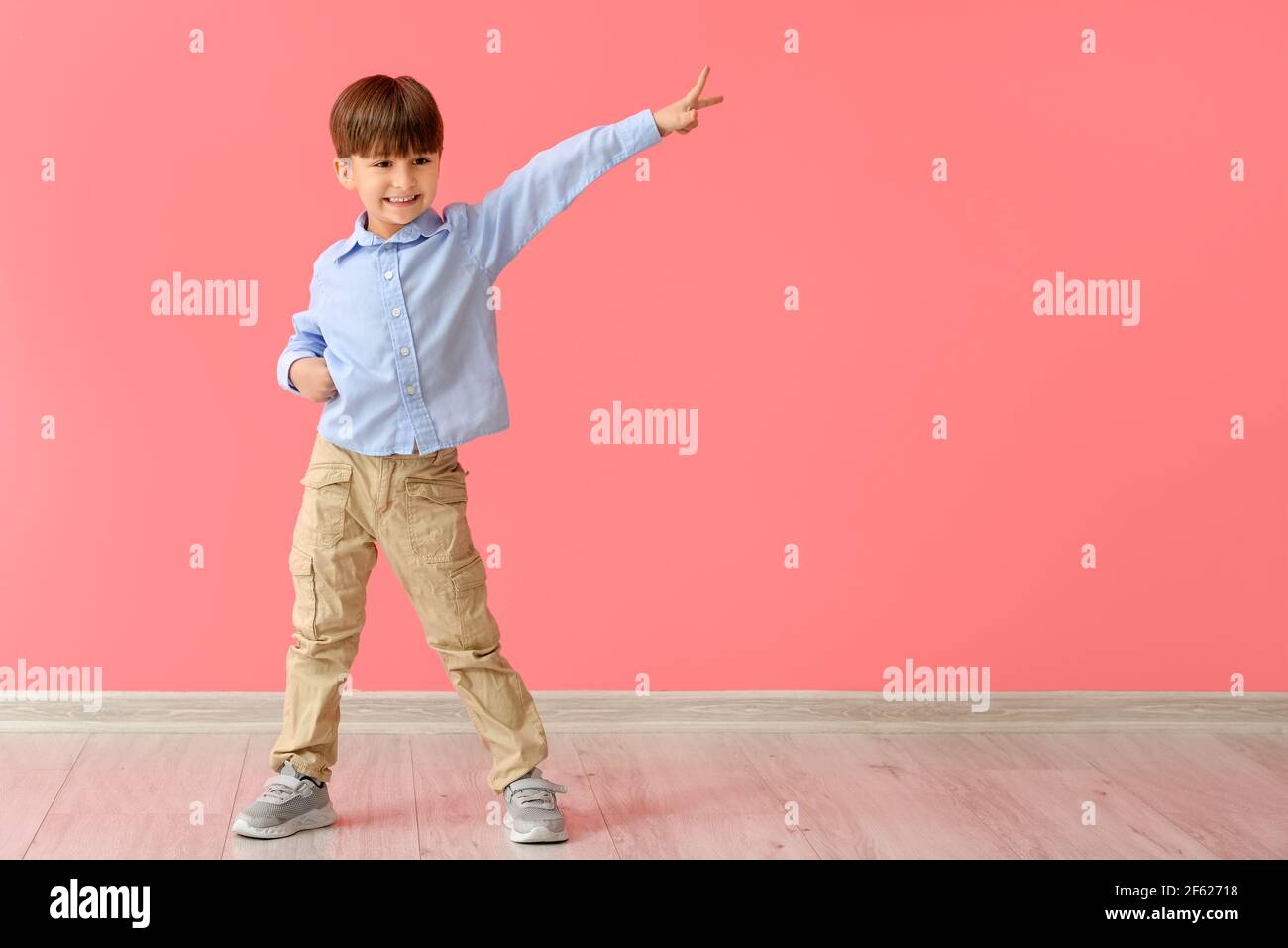 Happy little boy showing victory gesture near color wall Stock Photo ...