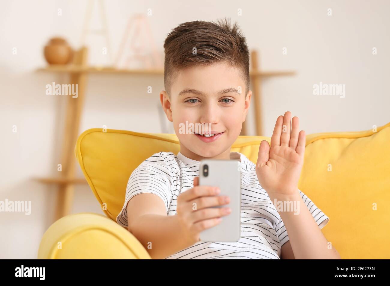 Happy little boy using mobile phone at home Stock Photo - Alamy