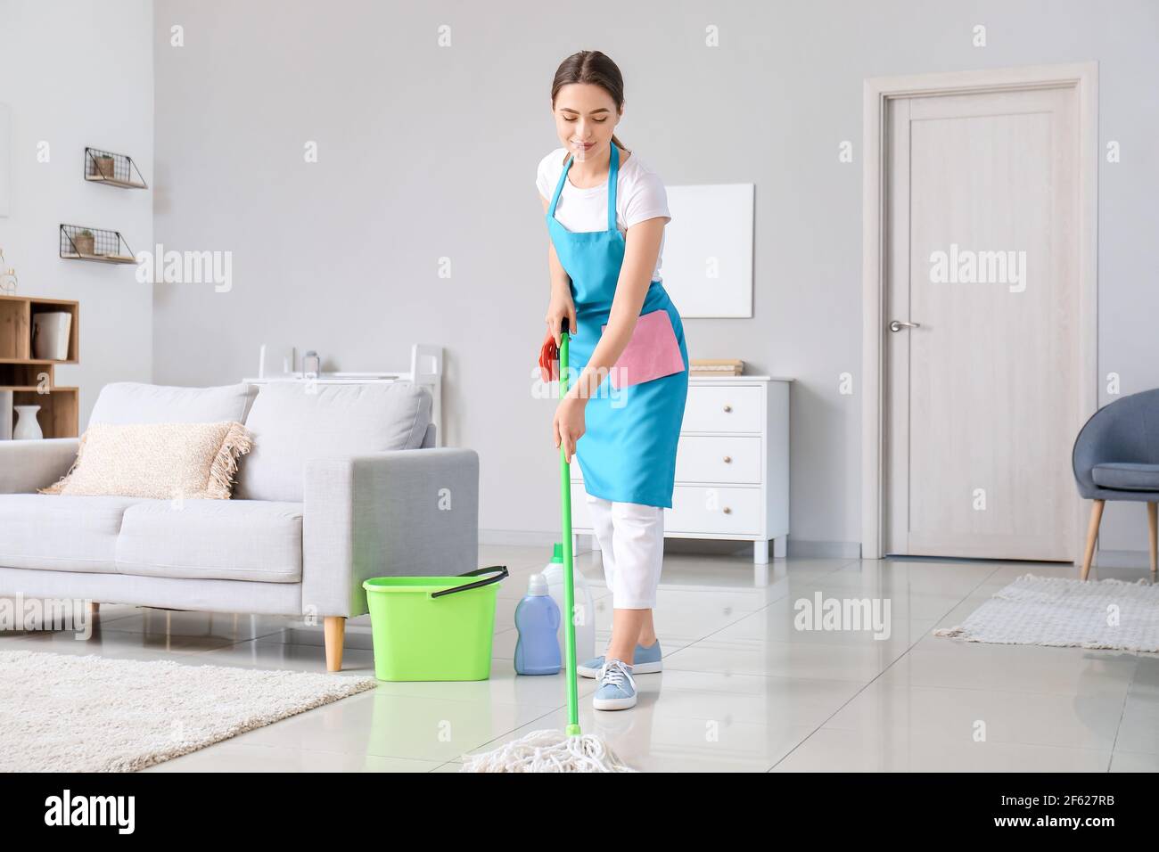 Young woman mopping floor in room Stock Photo - Alamy