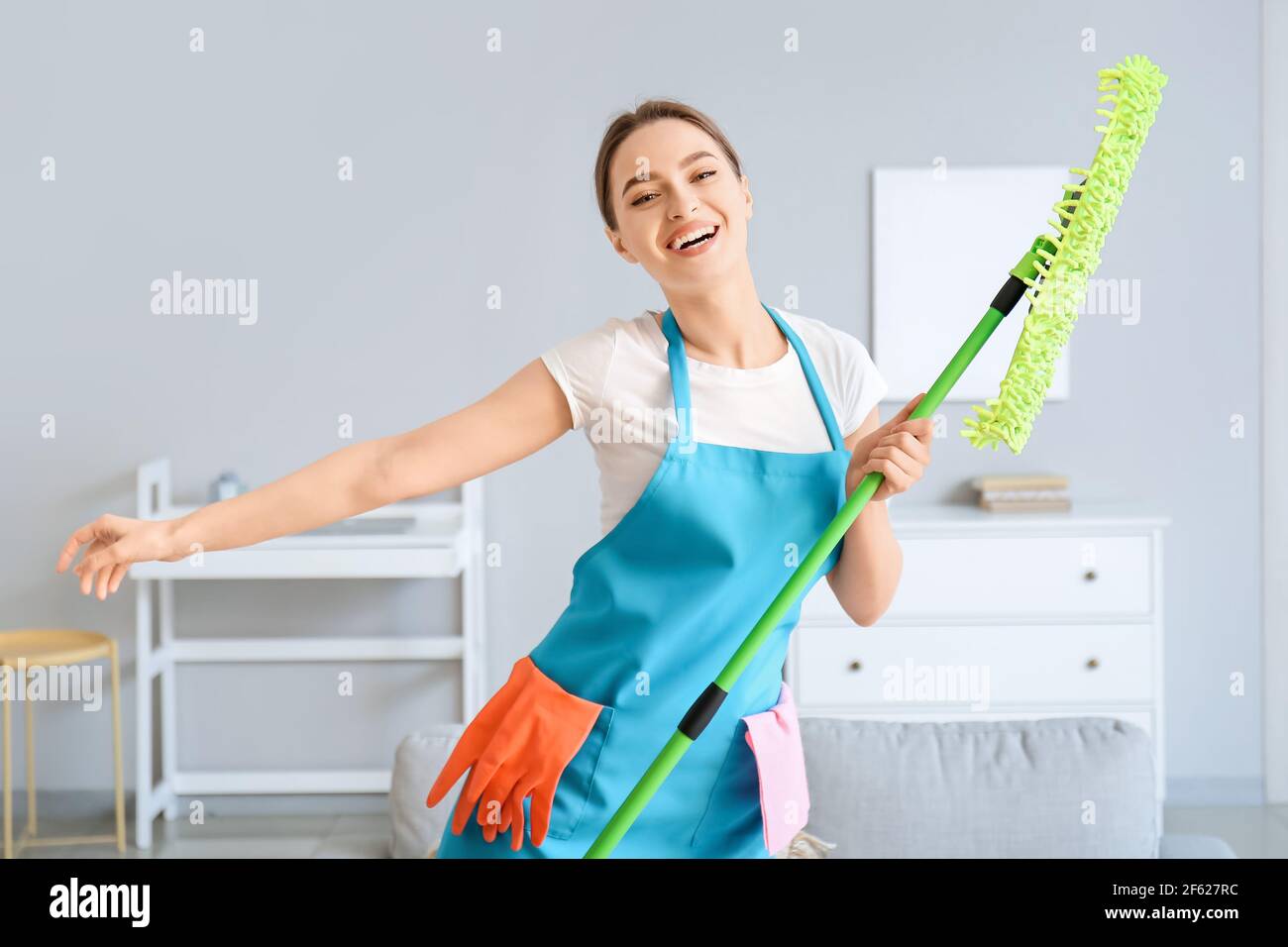 Young woman mopping floor in room Stock Photo - Alamy