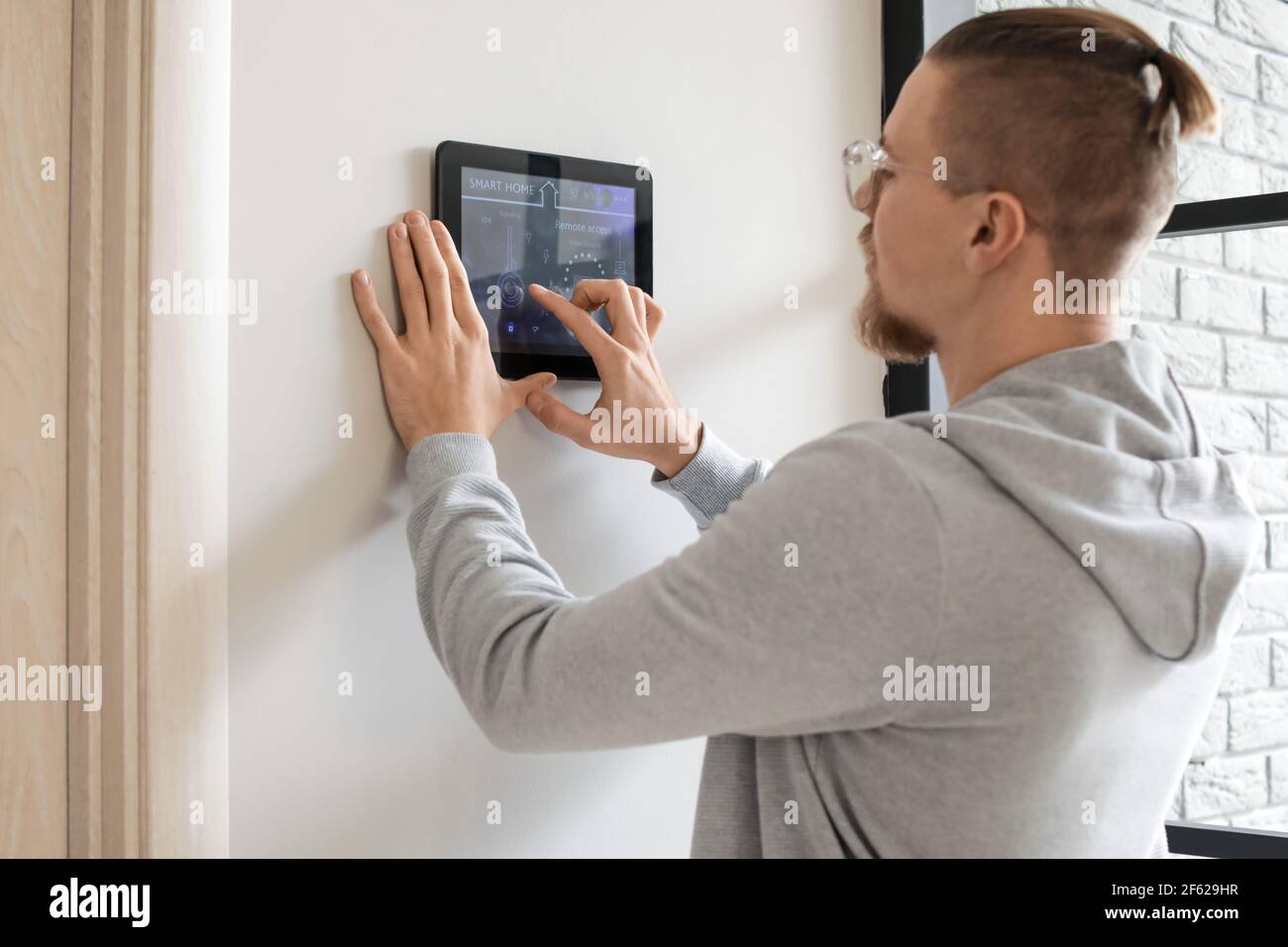 Man using smart home security system control panel Stock Photo - Alamy