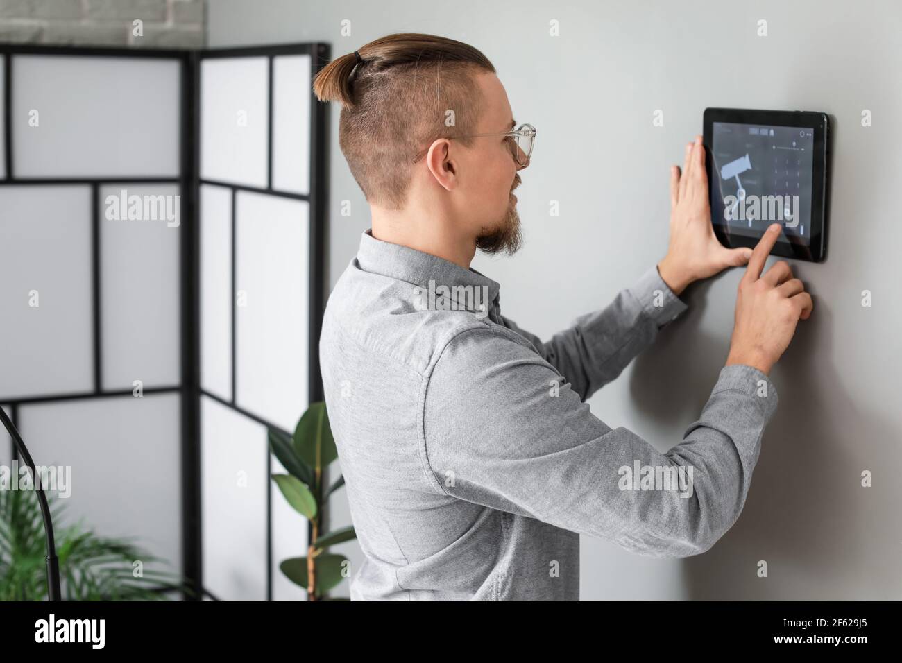 Man using smart home security system control panel Stock Photo - Alamy