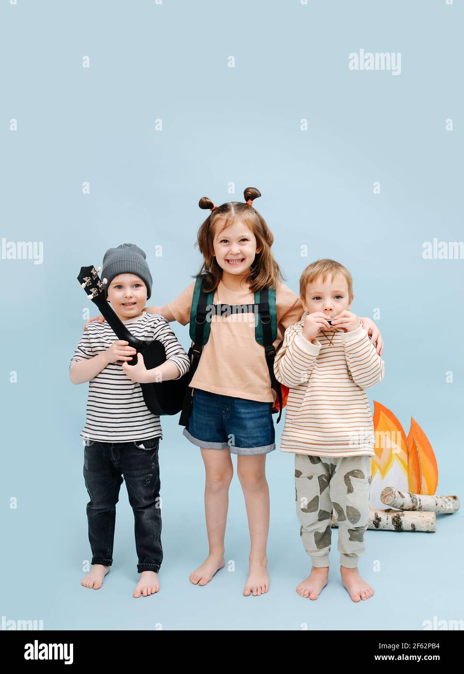 Grinning children standing next to a fake campfire with paper flames ...