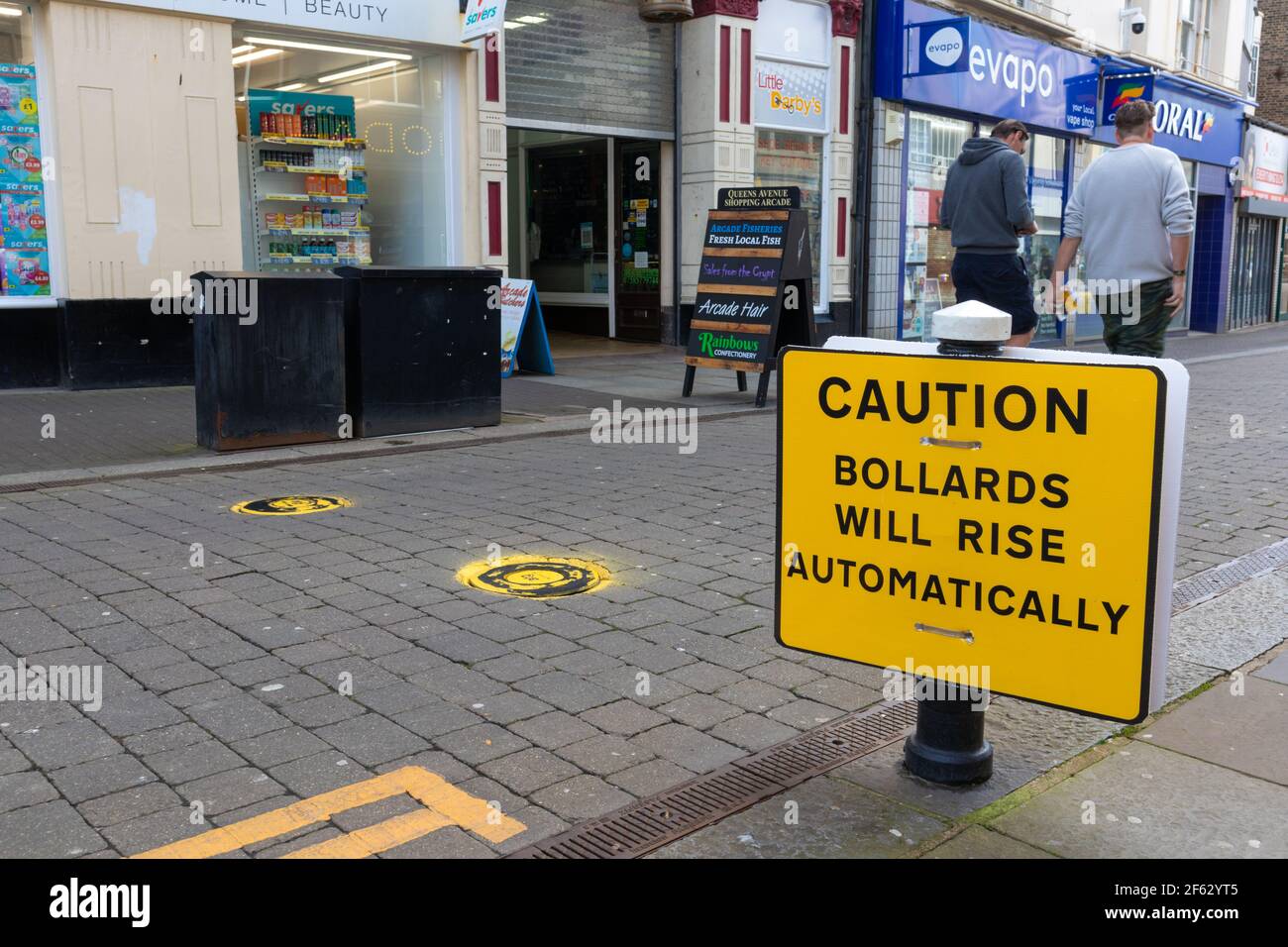 Caution bollards will rise automatically sign, pedestrian pavement ...