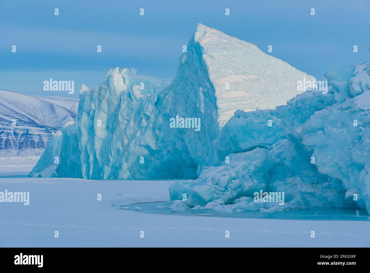 Frozen iceberg in front of mountain Stock Photo - Alamy