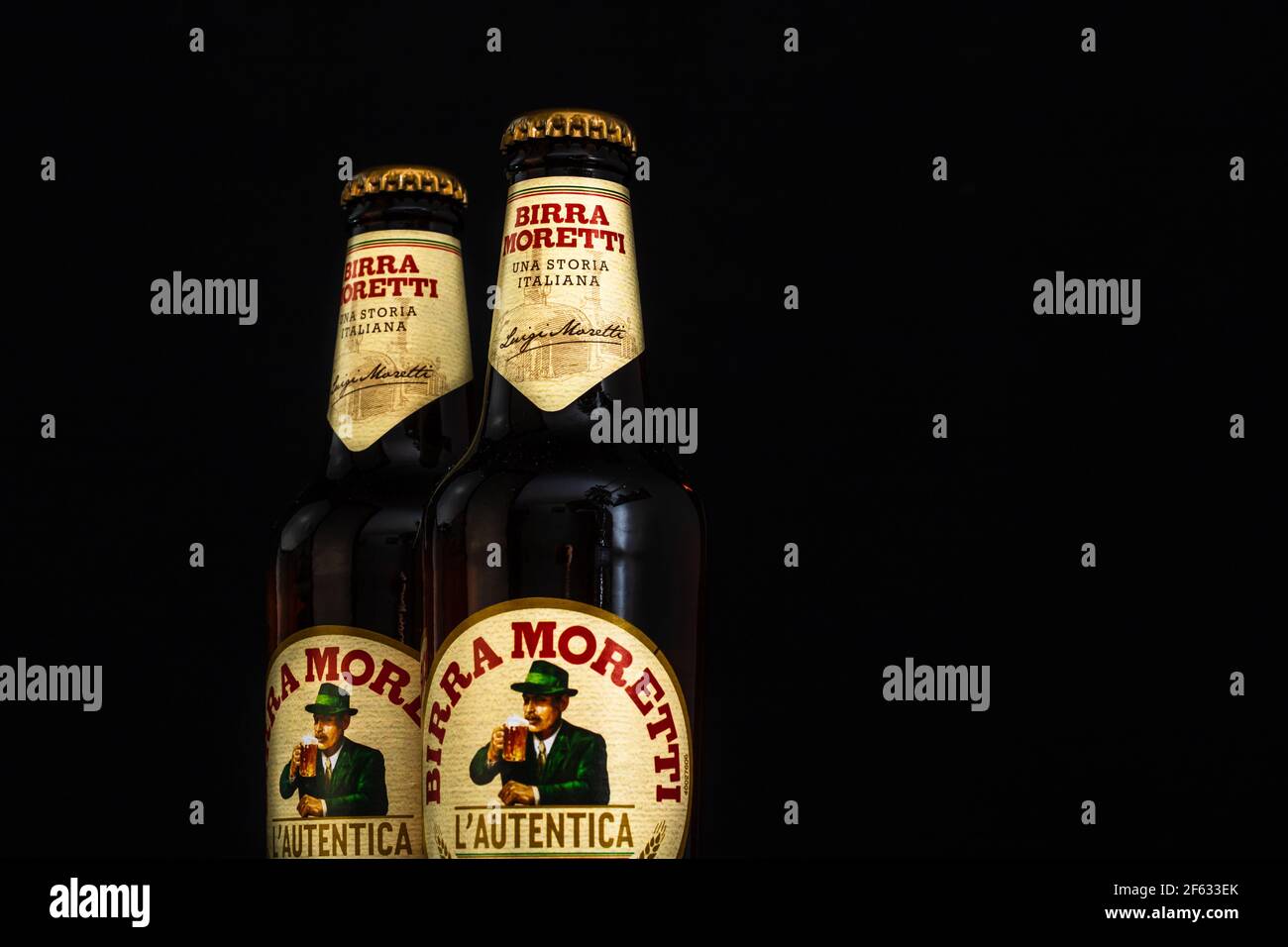 Bottle of Birra Moretti beer on wooden barrel with dark background ...