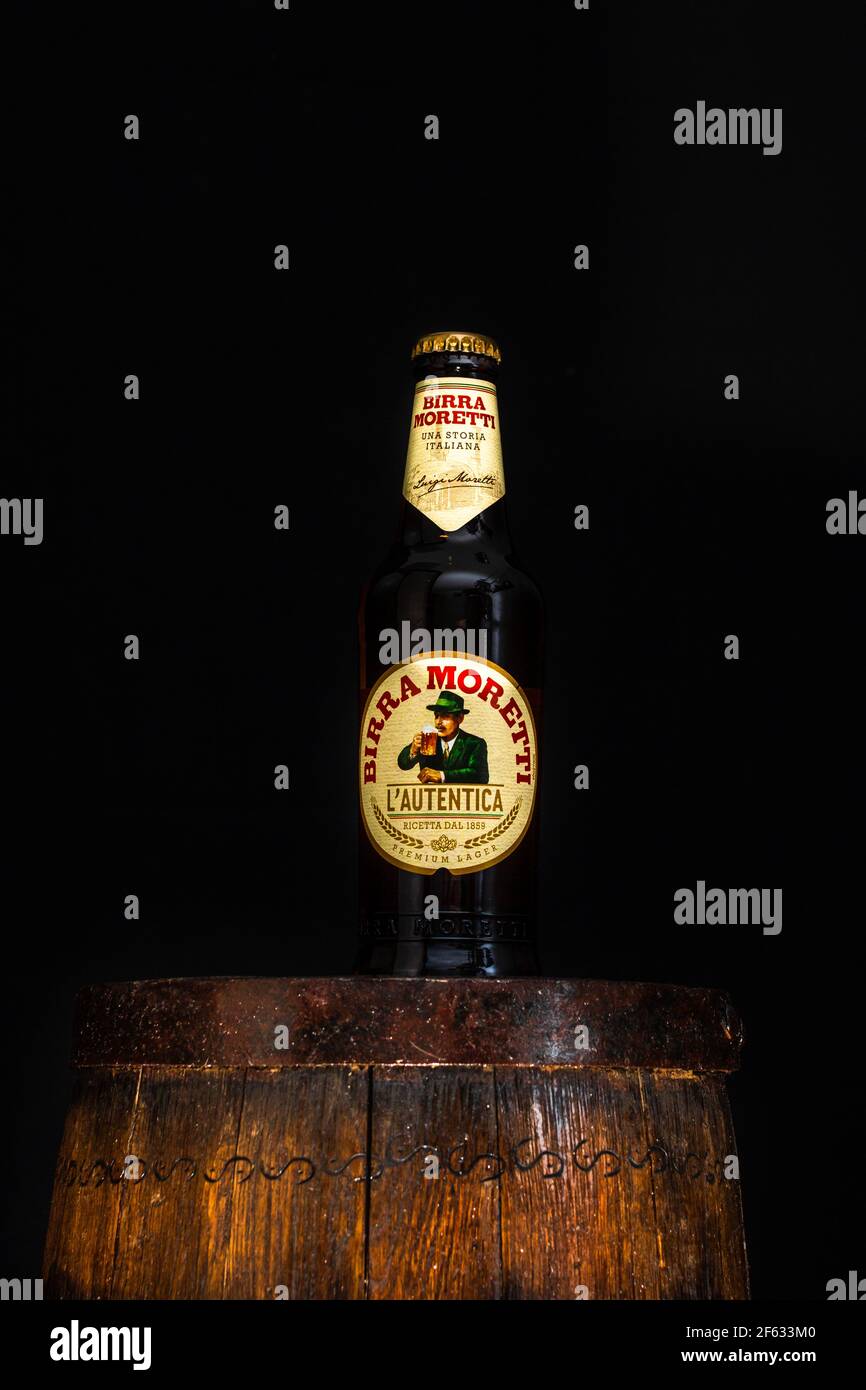Bottle of Birra Moretti beer on wooden barrel with dark background ...
