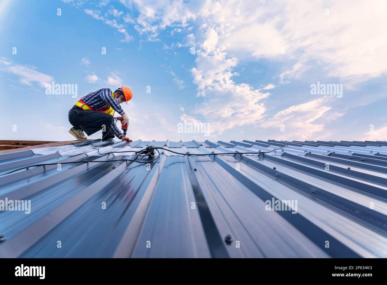 Roof construction concept, Roofer using air or pneumatic nail gun and ...