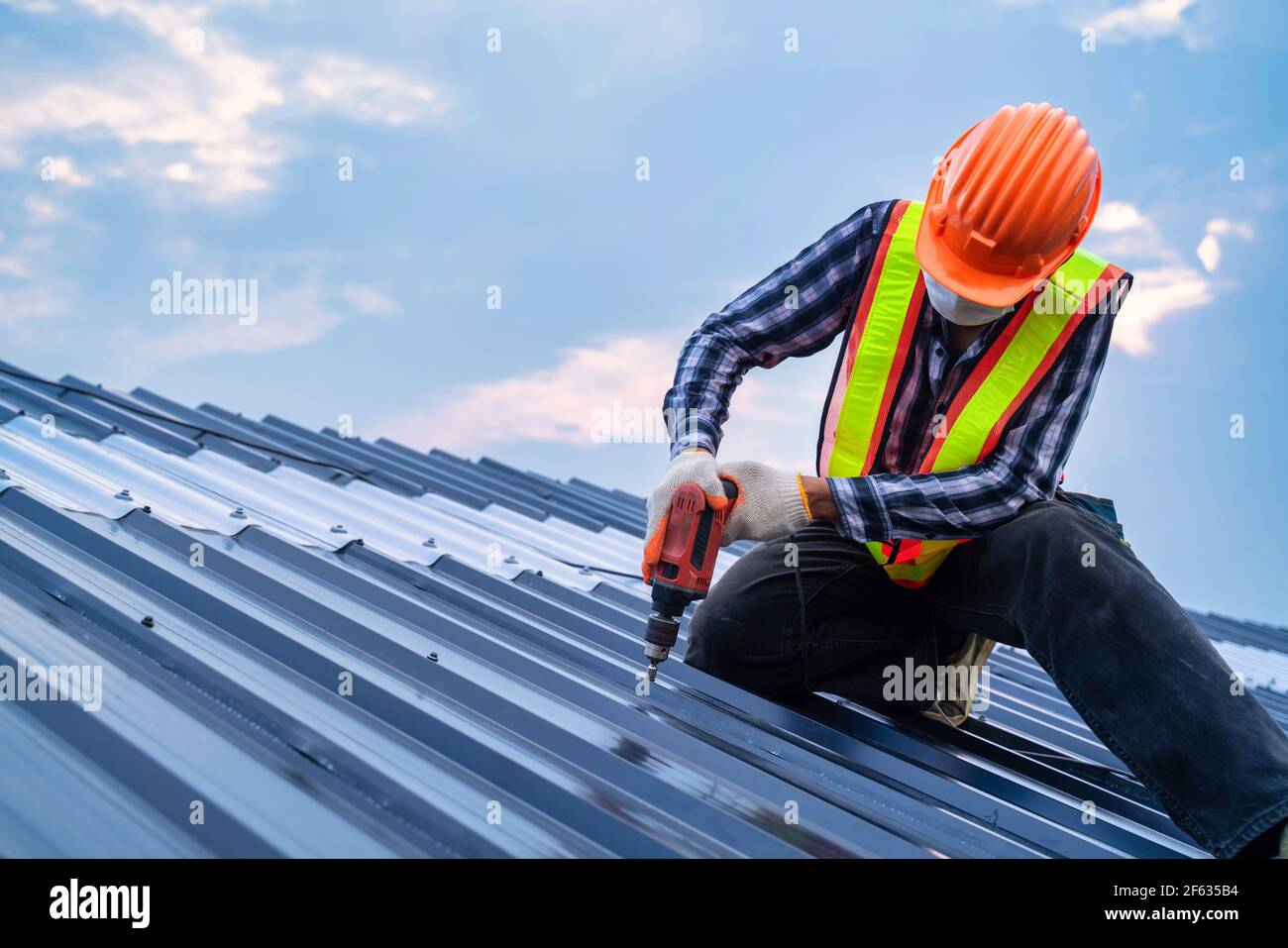 Close up Roofer worker safety wear using air or pneumatic nail gun and ...