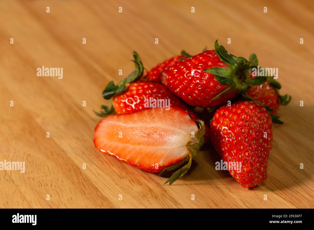 the sweet soft red fruit with a seed-studded surface cut in half on the ...