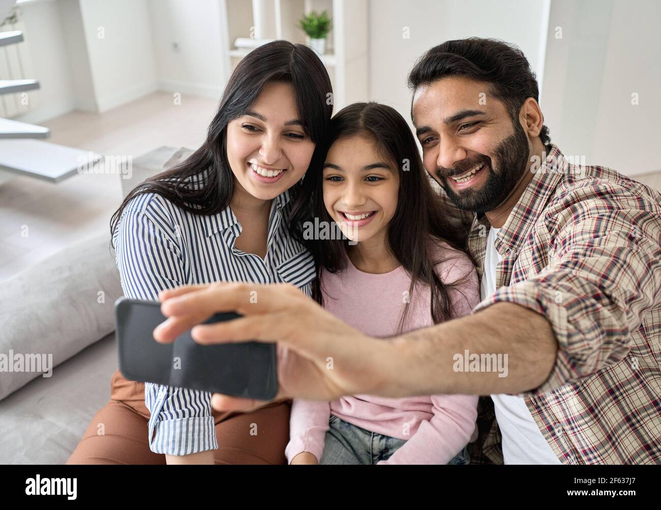 Happy indian family with teen daughter having video call on phone at ...