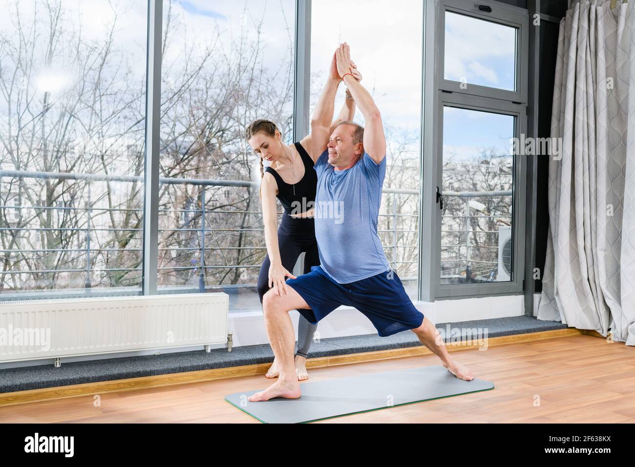 Middle age man make stretching workout exercises on mat in light ...