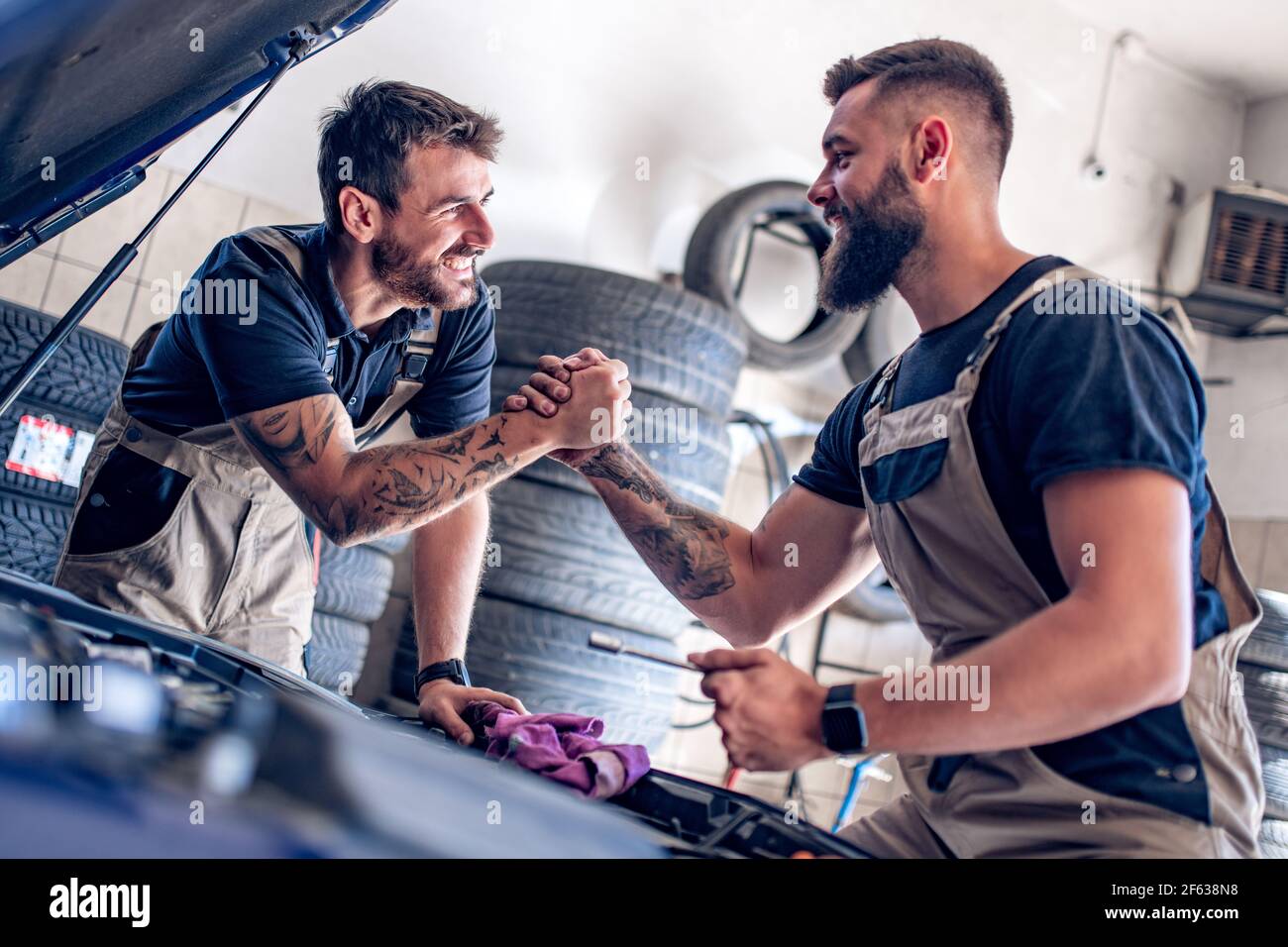 Auto mechanics check the oil in the engine,close up.Teamwork concept ...