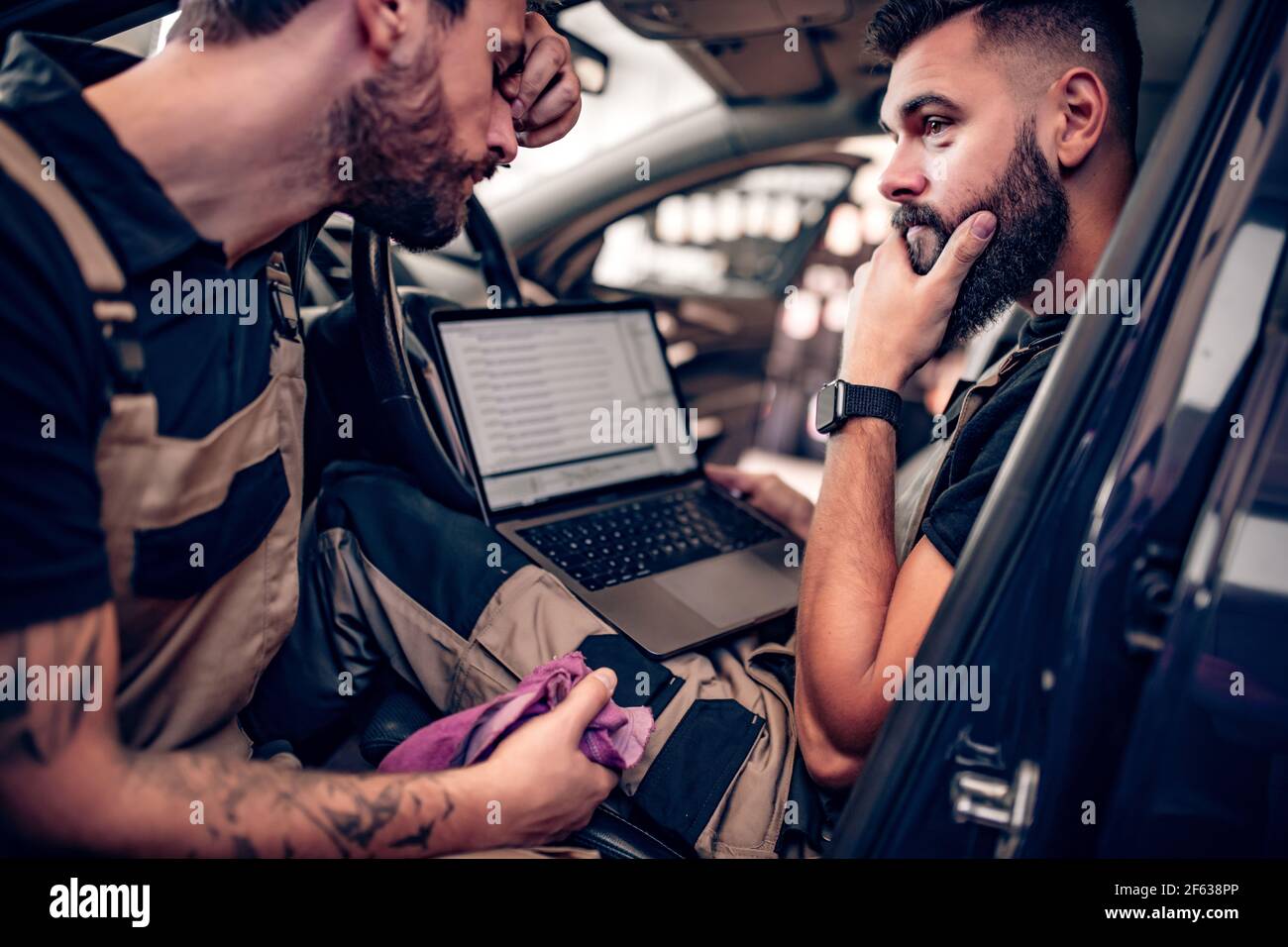 Two modern mechanics doing diagnostic in the car. Concept of work Stock ...