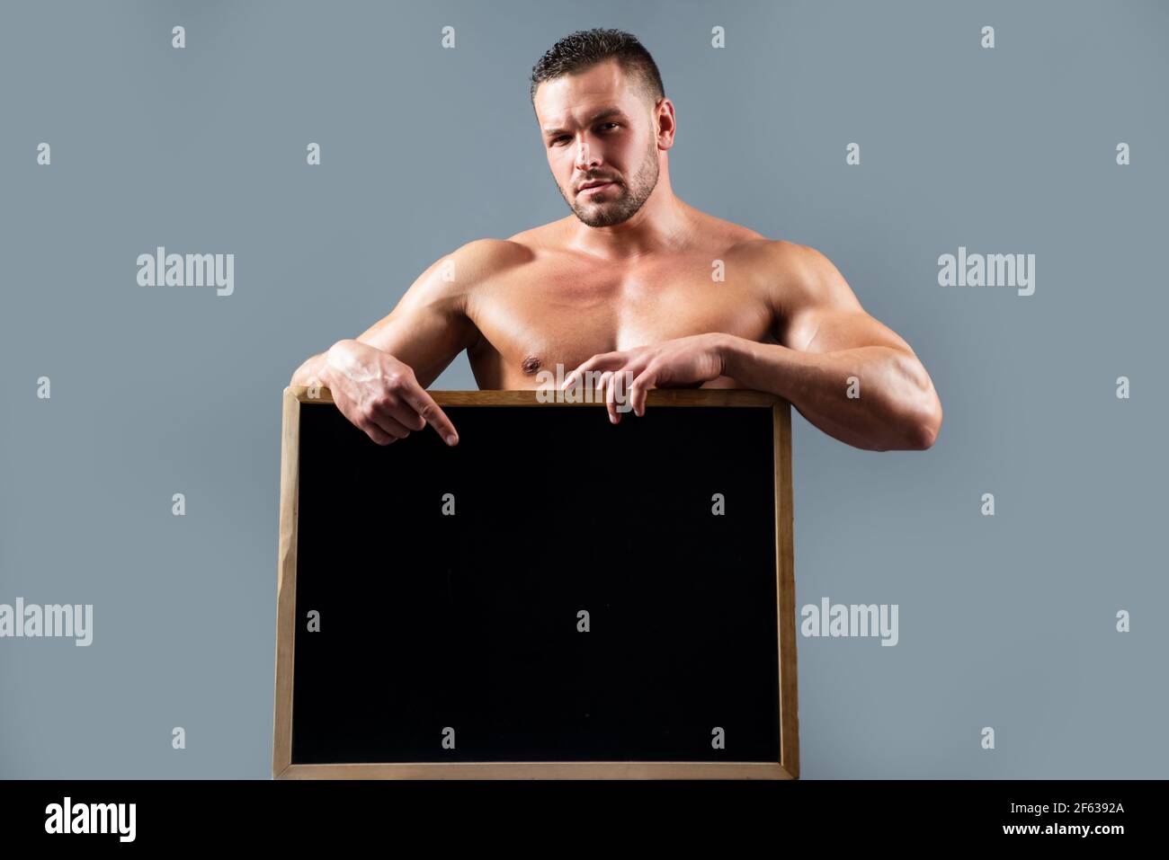 Bodybuilder man with sign advertising board. Strong athlete holding ...