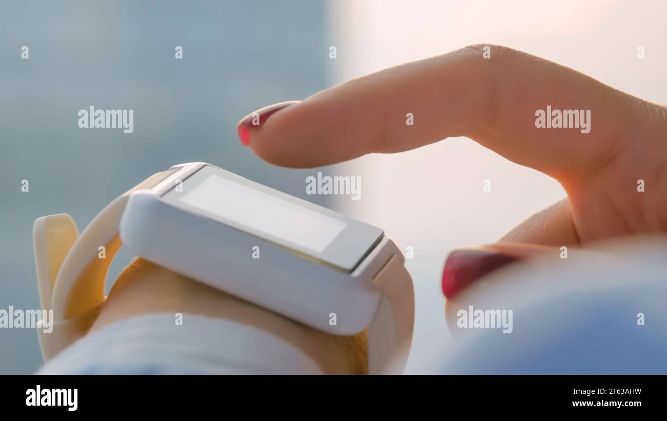 Woman using wearable white smart watch in office - close up side view ...