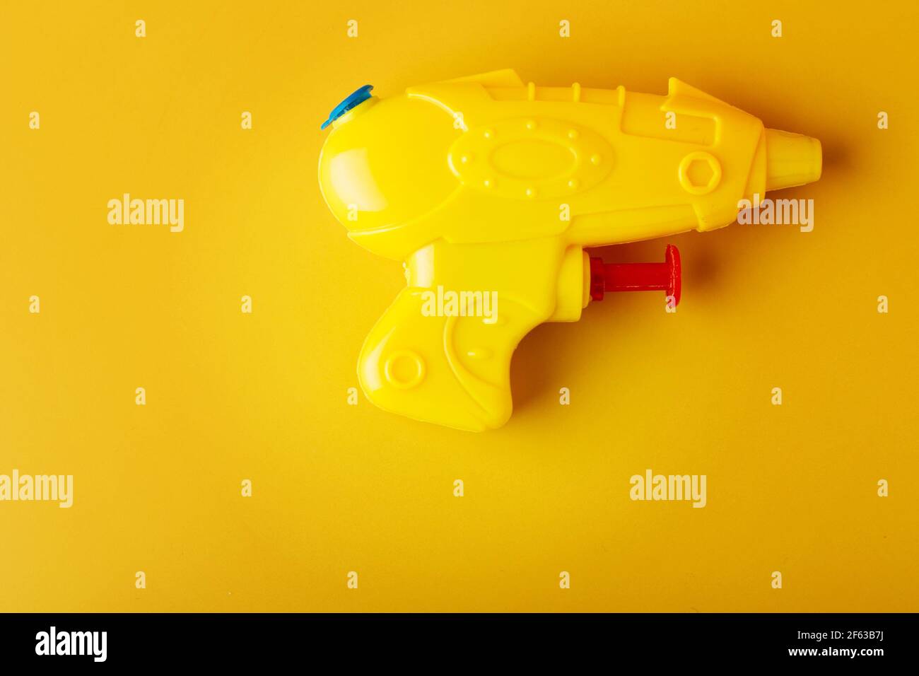 Plastic water gun on yellow background Stock Photo - Alamy