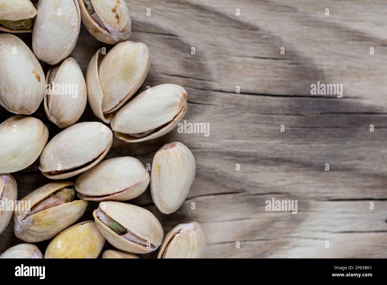 Lots of pistachios in their shell on a wooden chopping board. Natural ...