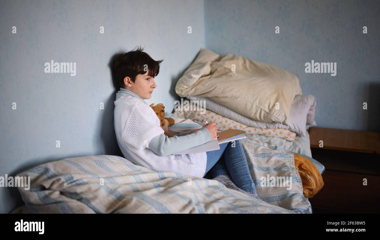 Poor sad small girl on bed indoors at home, poverty concept Stock Photo ...