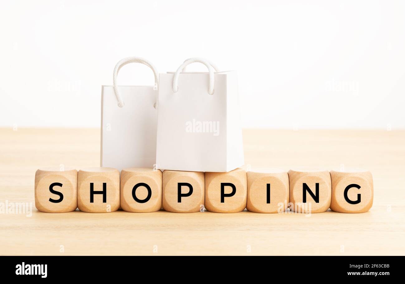 Shopping concept. Text on wooden blocks on table and paper shopping ...