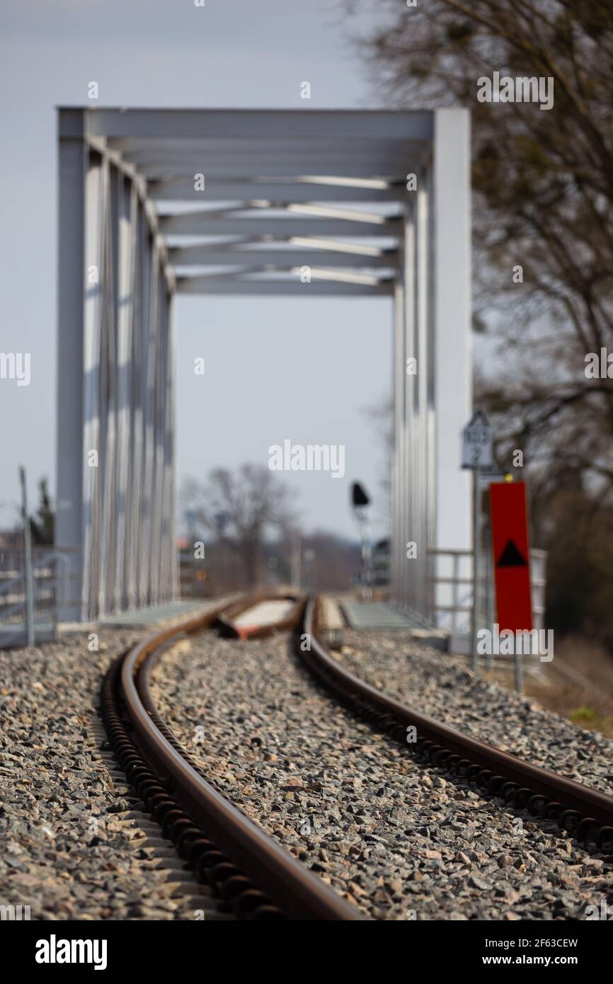 View along the railroad tracks of the white steel bridge. Natural, soft ...