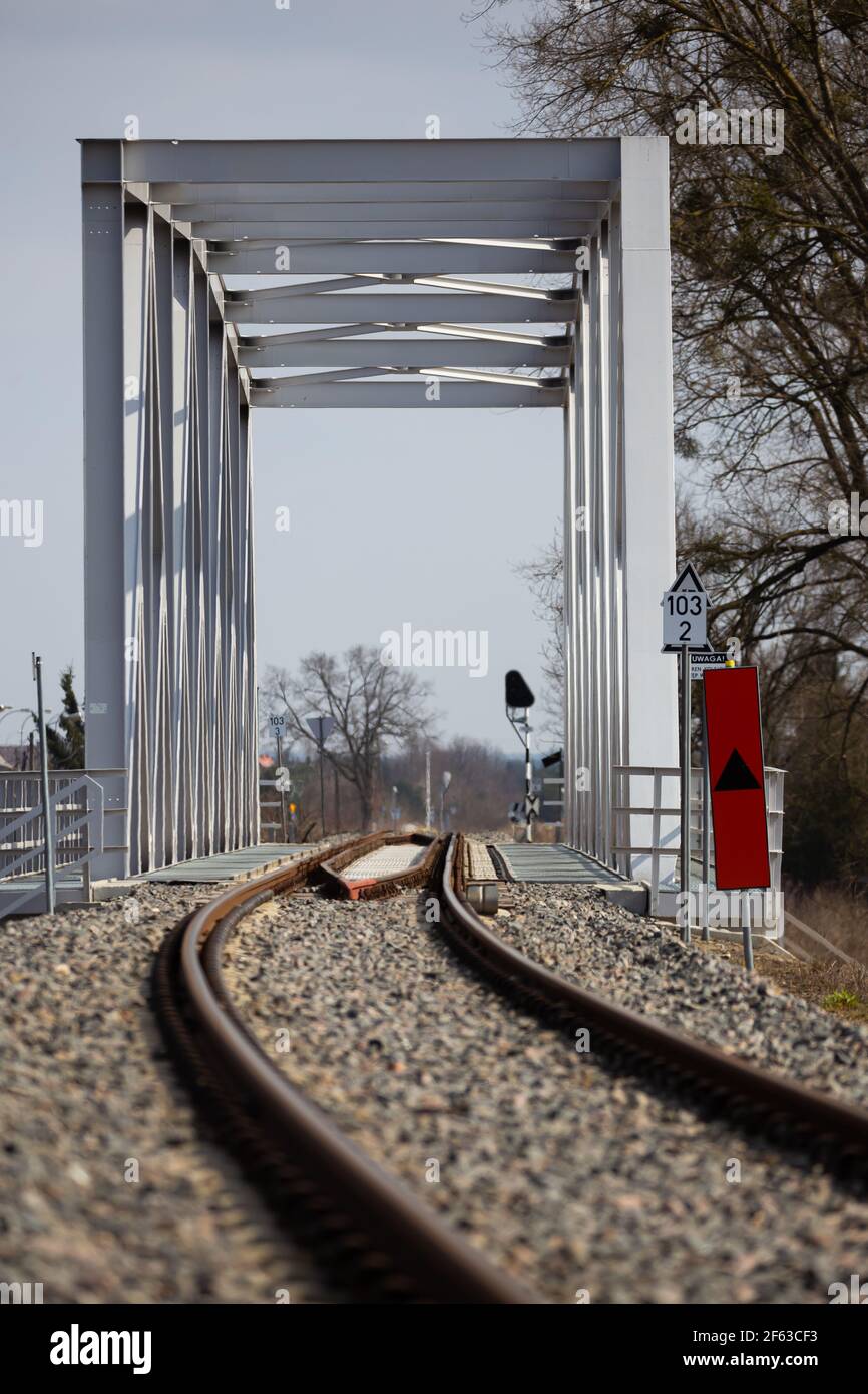 View along the railroad tracks of the white steel bridge. Natural, soft ...