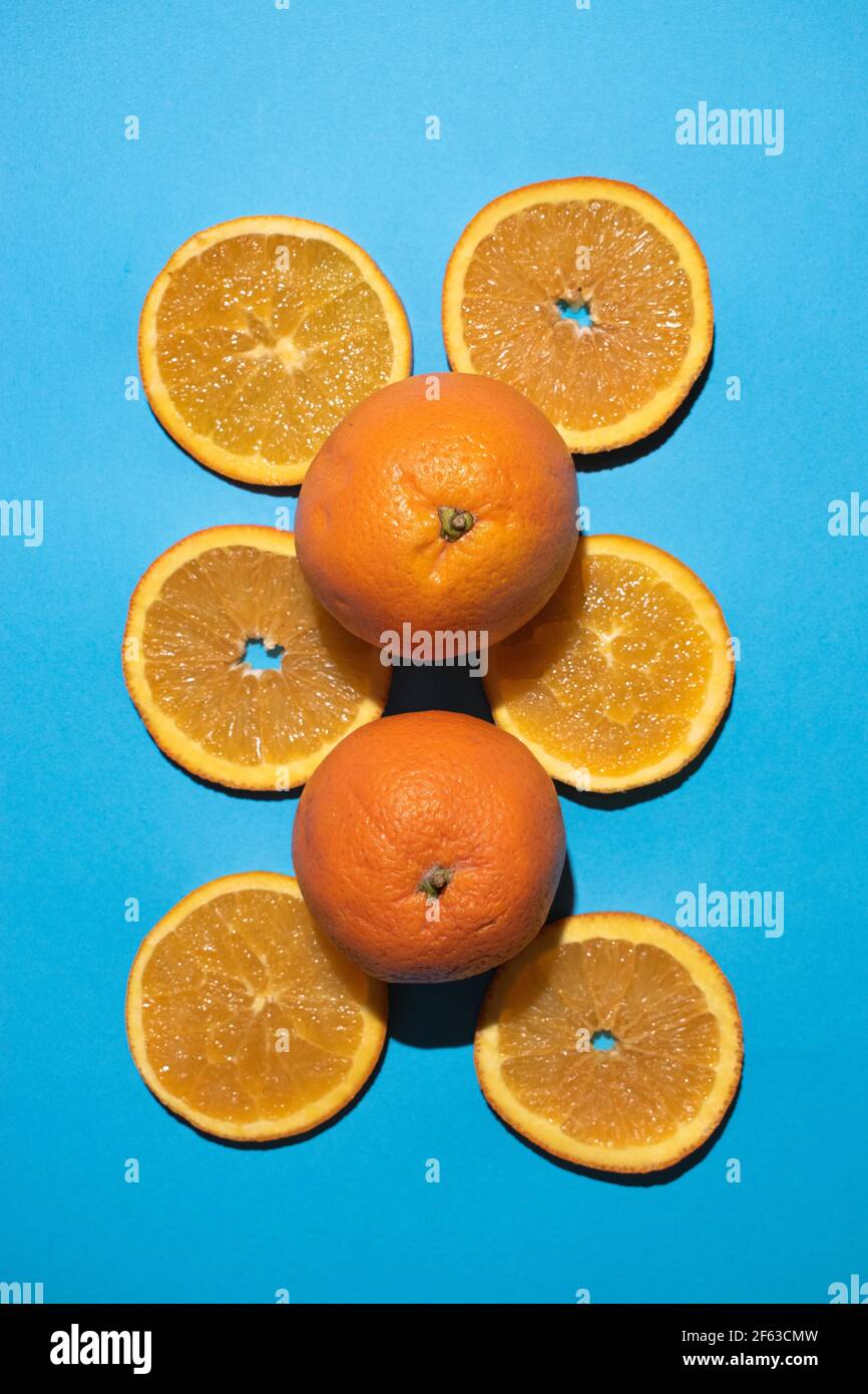 Orange slices parallel to each other with two whole oranges centered in ...