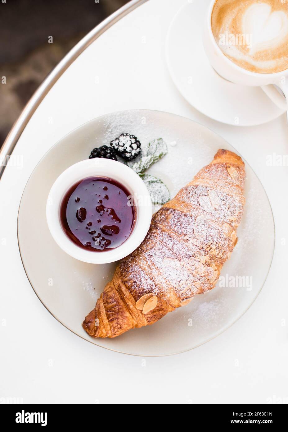Cup of coffee with heart drawing, croissant and jam on black background ...