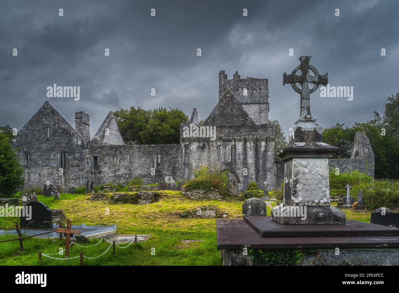 Ancient graveyard with Celtic cross tombstone and ruins of 15th century ...