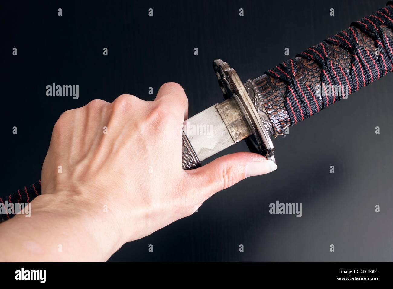 Samurai sword and scabbard in hand on wooden background close up Stock ...