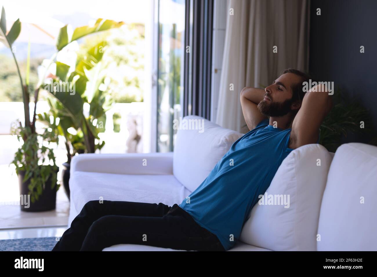 Caucasian man sitting on sofa relaxing with eyes closed Stock Photo - Alamy