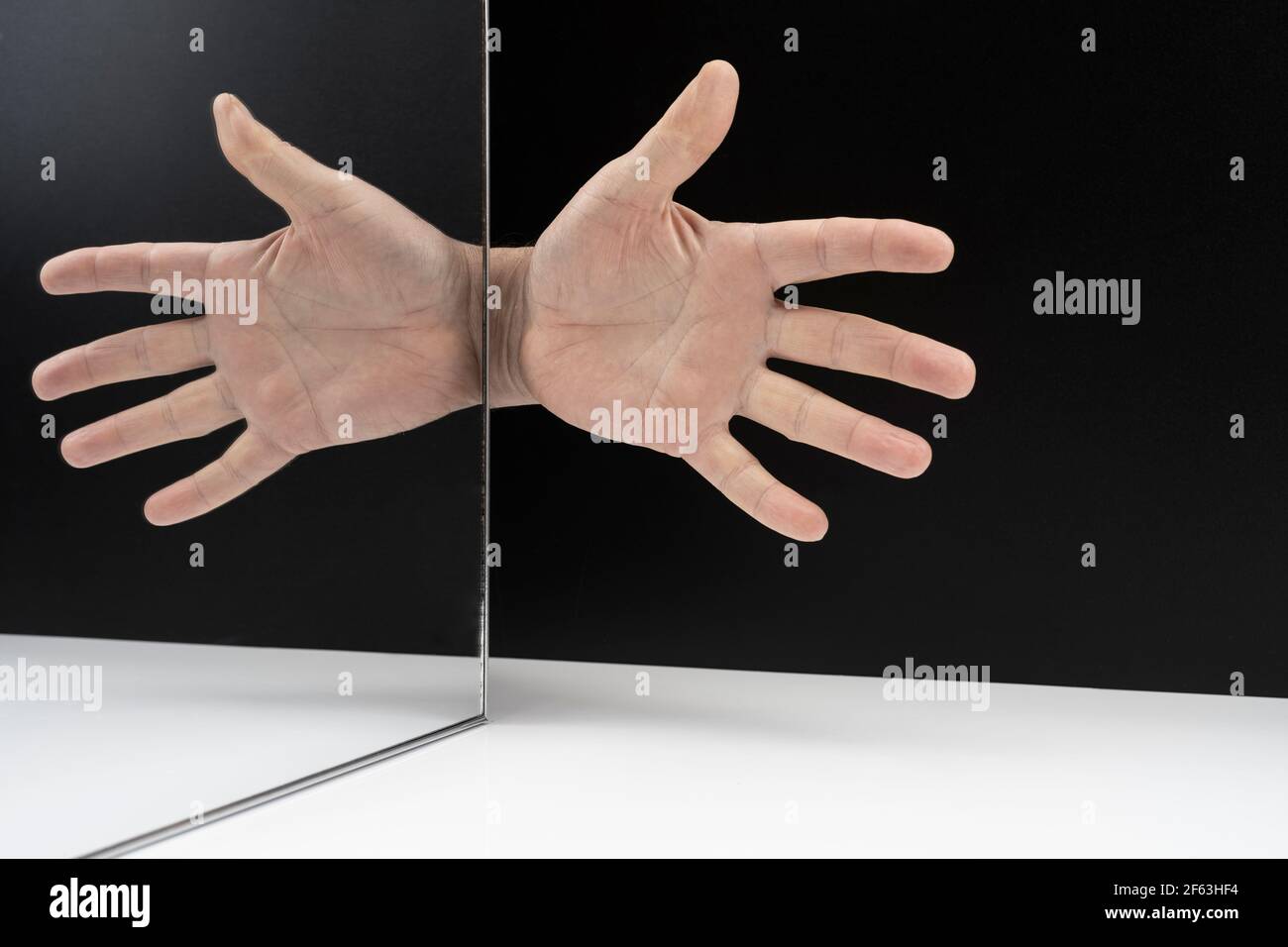 hand from behind the mirror pointing with finger Stock Photo - Alamy