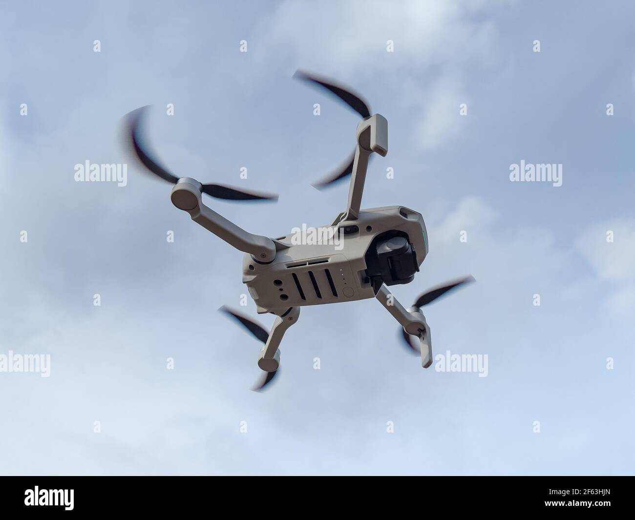 Grey drone with camera flying in the air outdoors. Little drone flying ...