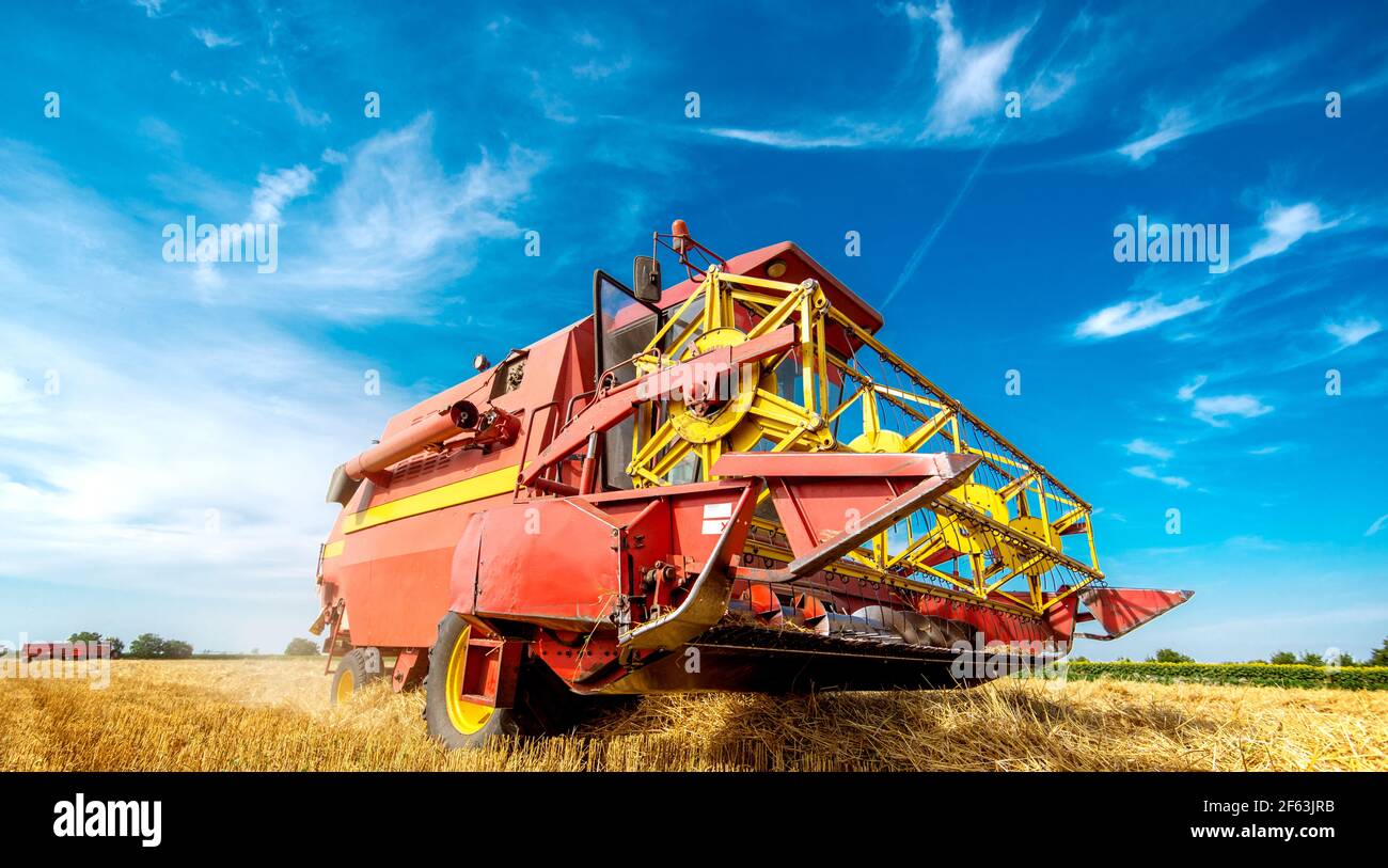Giant red and yellow combine harvester standing in the middle of a ...