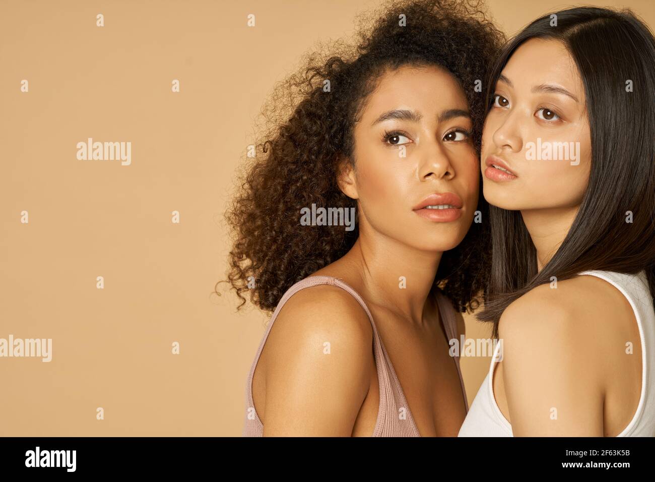 Portrait of two gorgeous mixed race young women with perfect skin ...