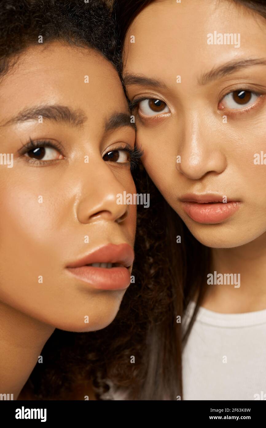 Face closeup of two beautiful mixed race young women with perfect ...
