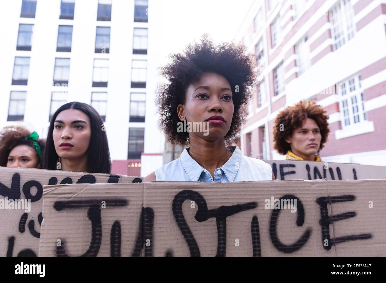 Three diverse male and female protesters on march holding homemade ...