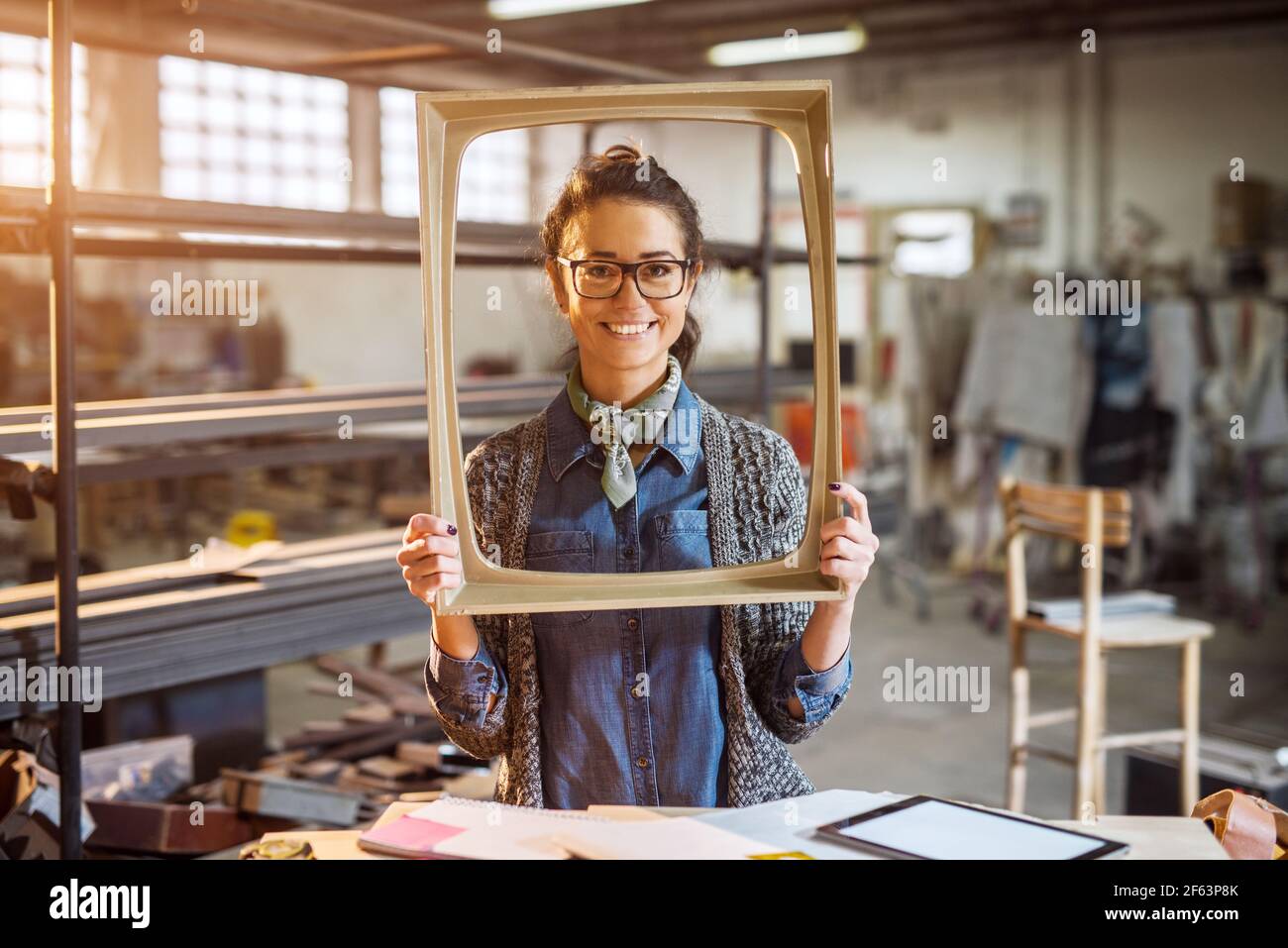 Excited middle-aged engineer holding old fashion picture frame in sunny ...