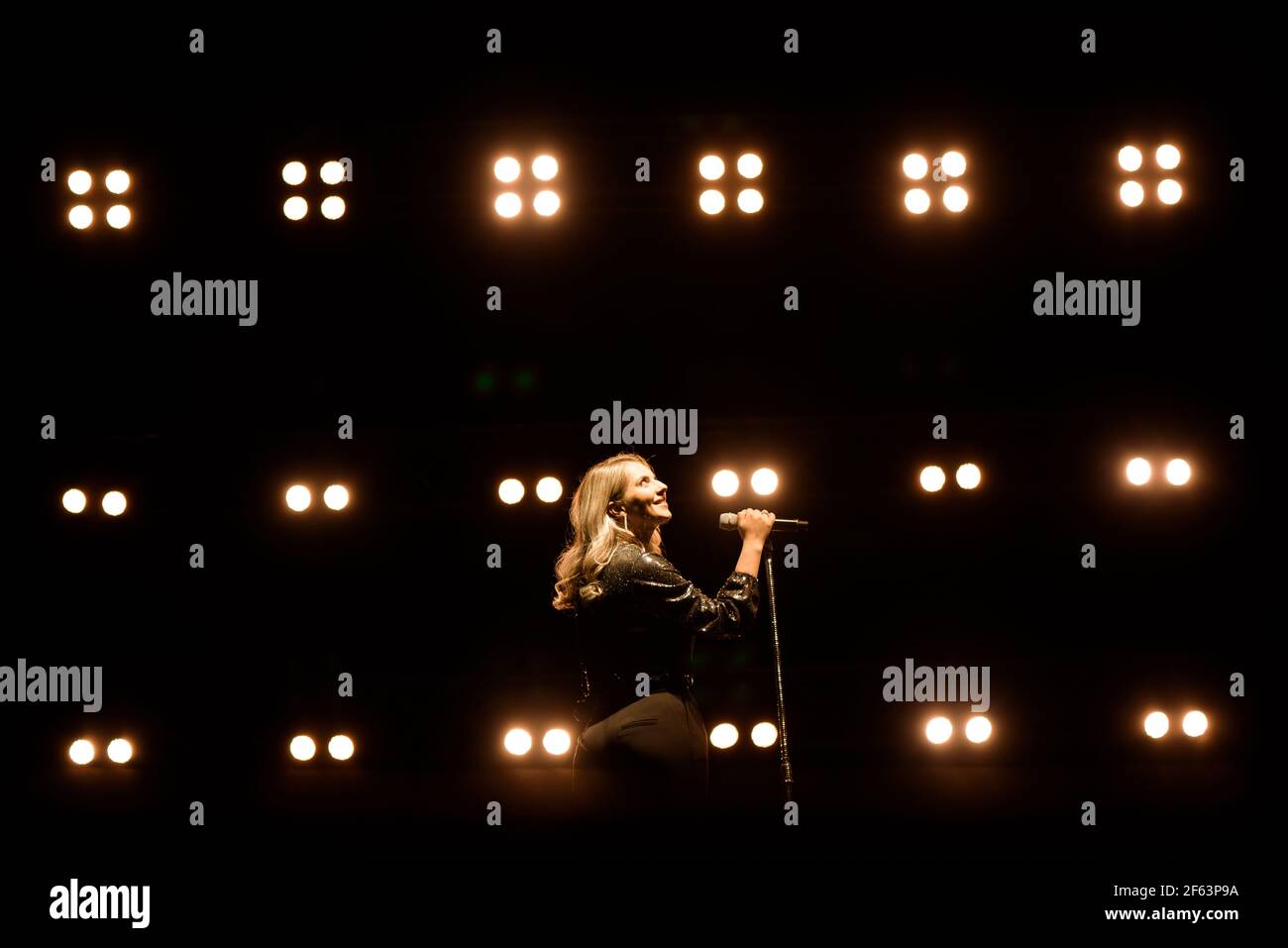 Singer on scene in the club. Bright stage lighting Stock Photo - Alamy