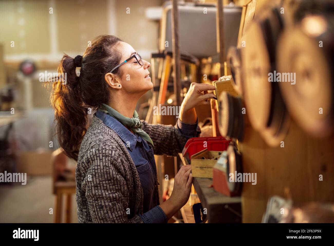 Side view of cheerful hardworking middle-aged industrial female ...