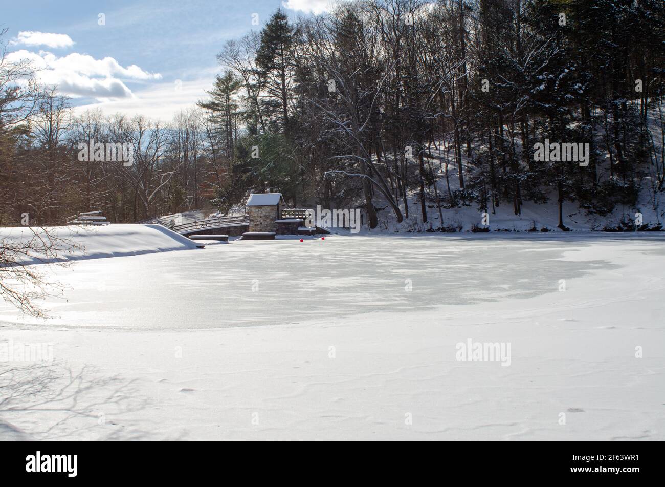 Snow covered dam and frozen over lake at a state park after a blizzard ...