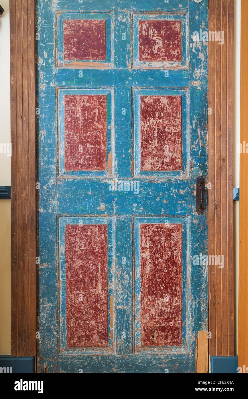 Blue and reddish distressed wooden door of master bedroom inside an old ...