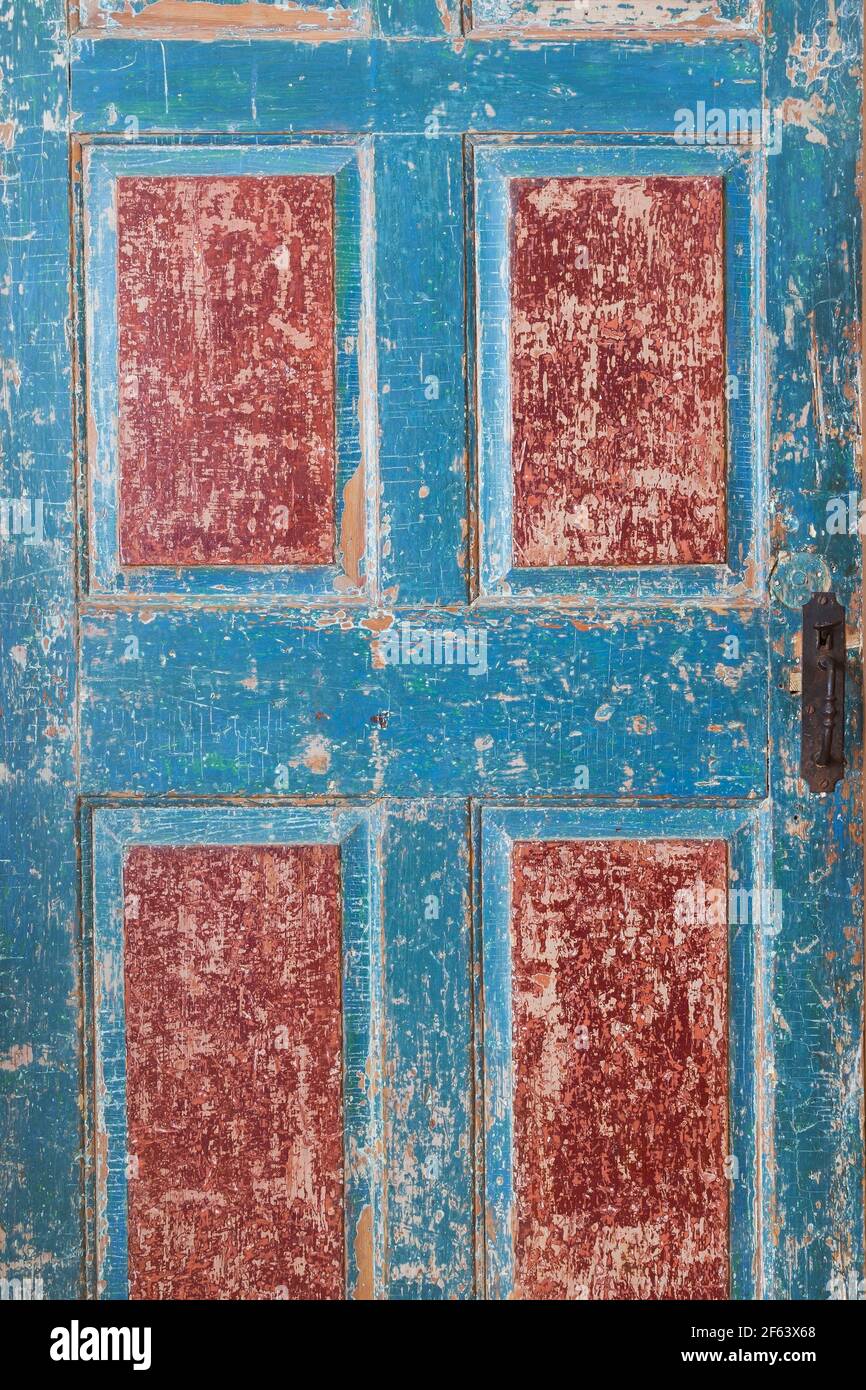 Blue and reddish distressed wooden door in master bedroom inside an old ...