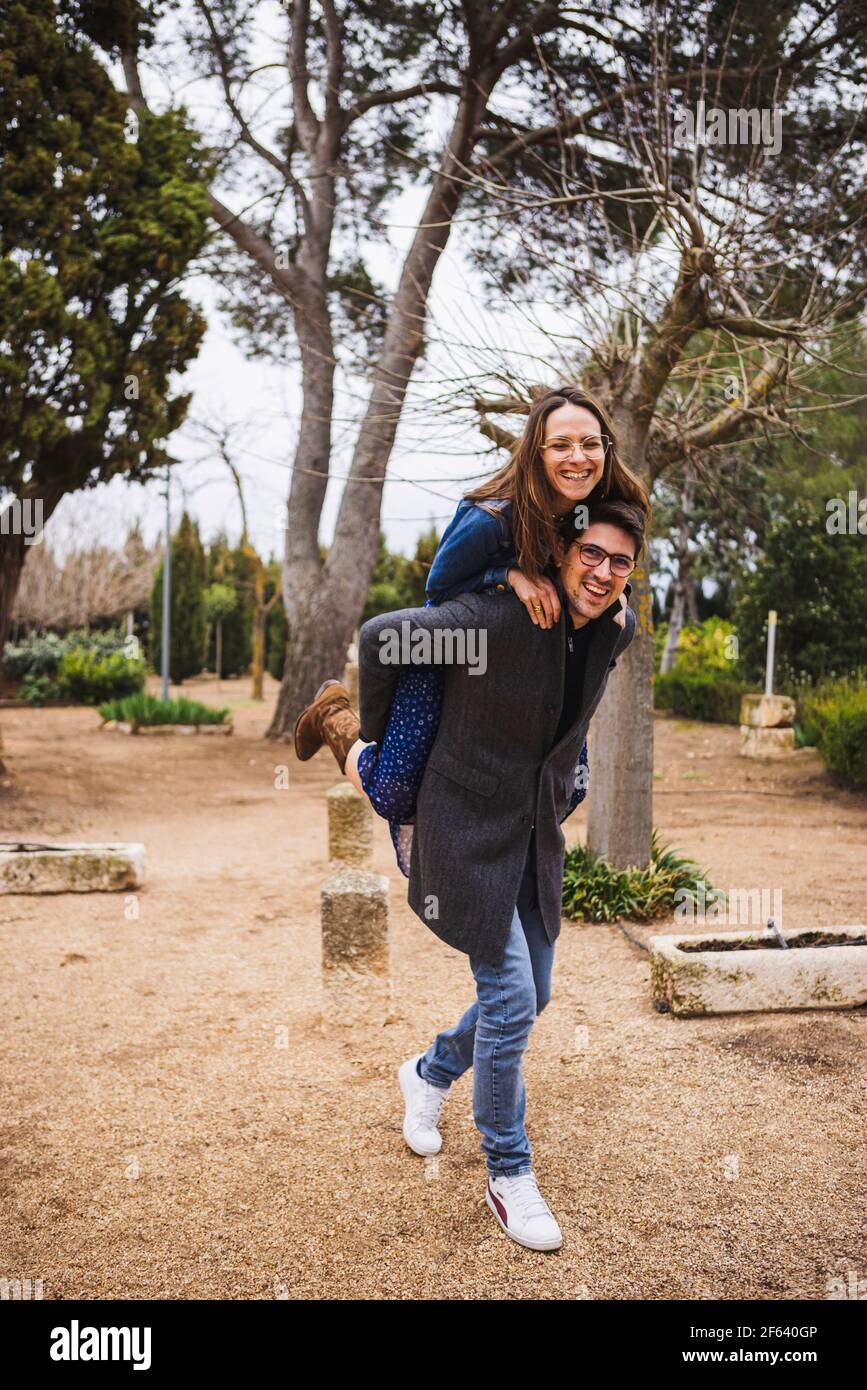 Young girl climb on the back of her boyfriend, piggyback, having fun ...