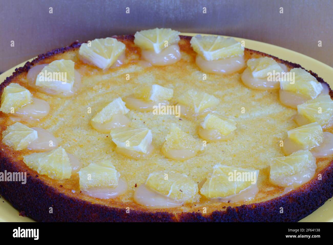 A round boiled Meyer lemon, almond and olive oil cake with sliced ...
