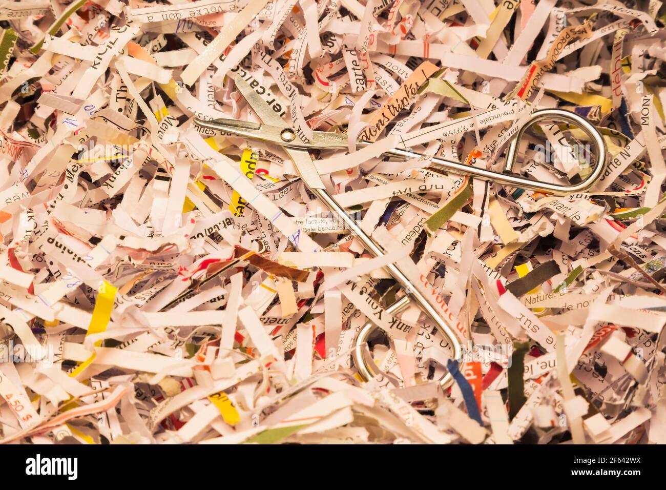 Close-up of pair of steel scissors on top of shredded paper pile Stock ...